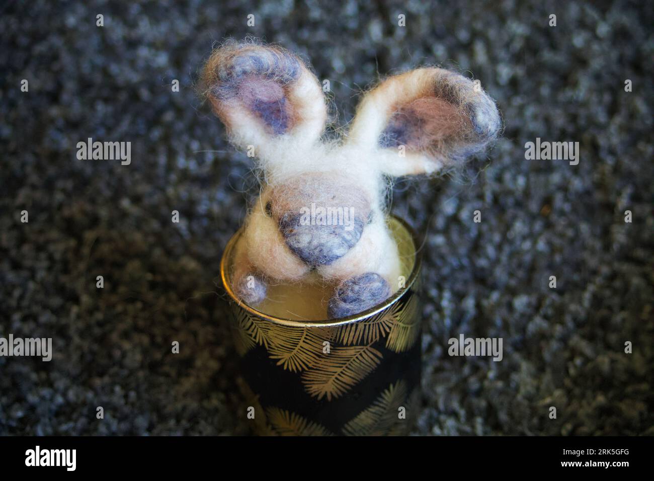 A plush toy rabbit placed in a silver metal container with a shining ...