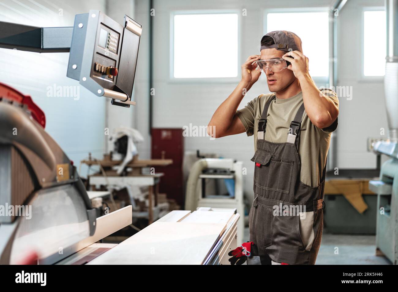 Male carpenter using some woodworking tools for his work in a factory ...