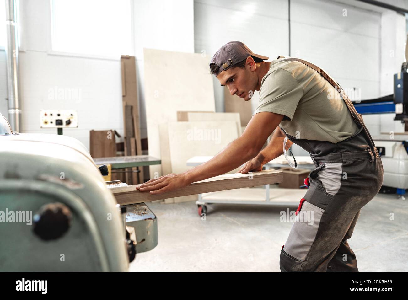 Male carpenter using some woodworking tools for his work in a factory ...