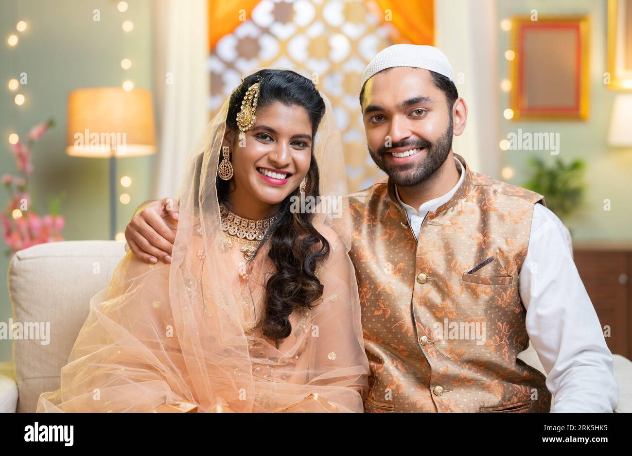 Happy smiling indain Muslim couple embracing by looking at camera while ...