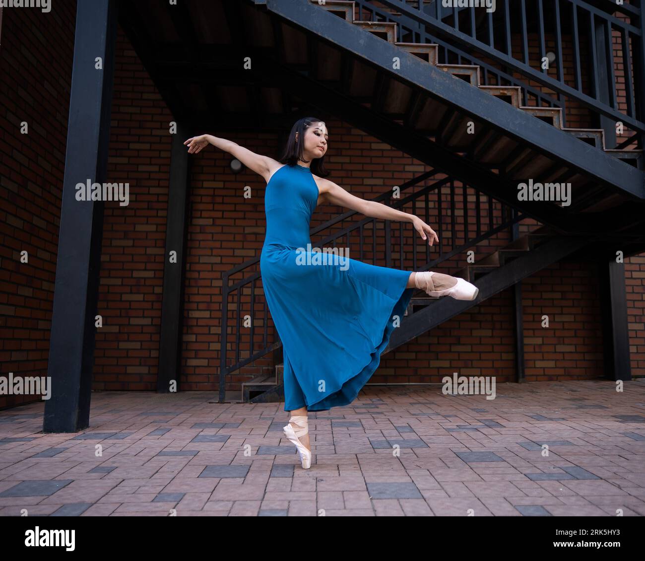 Beautiful Asian ballerina dancing outdoors. Urban landscape Stock Photo ...