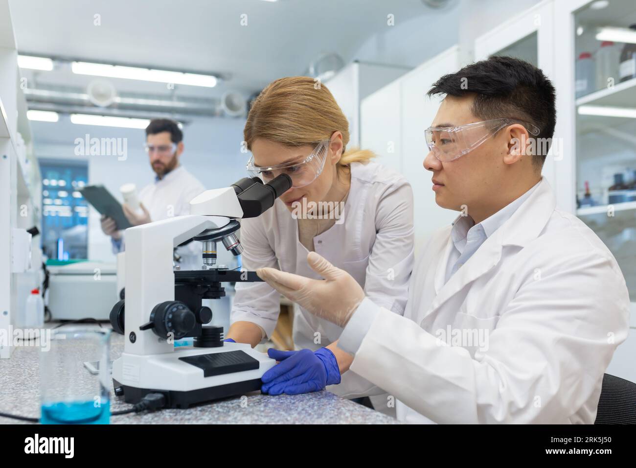 A diverse team of doctors and scientists works in the laboratory. Asian ...