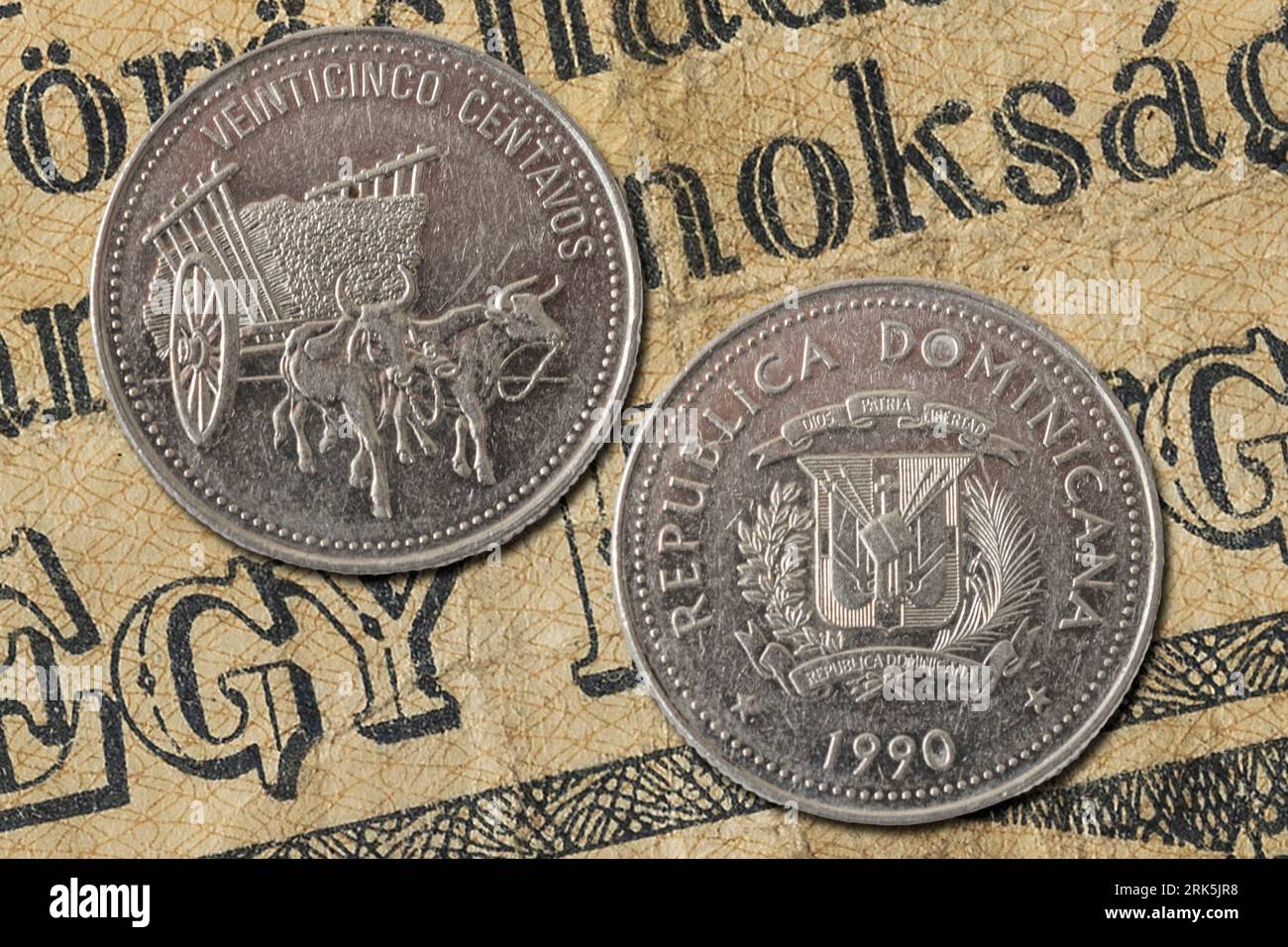 A closeup of two Dominican Republic coins on an aged currency bill ...