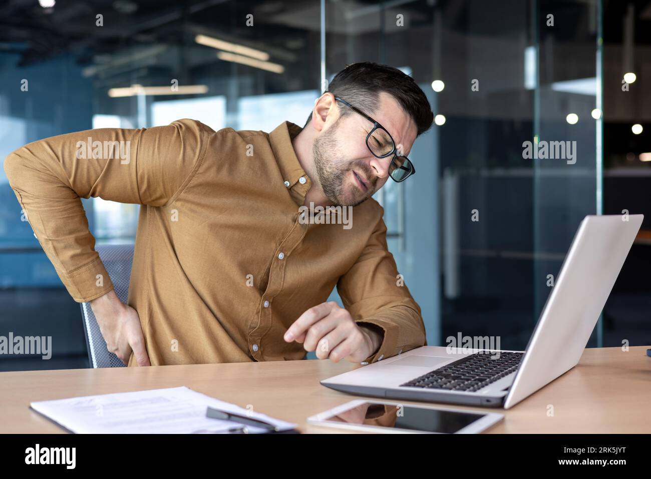 Injury at the workplace. A young man works in the office at a table ...