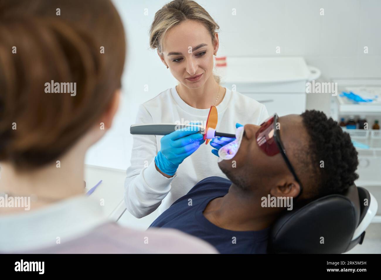 Dentist nurse treating patient in hi-res stock photography and images ...