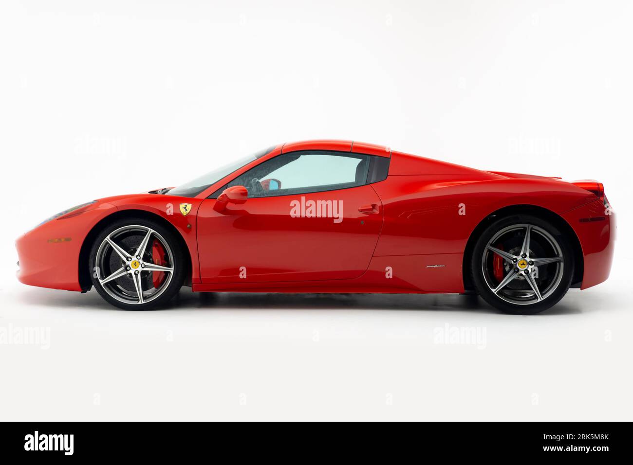 A bright Red Ferrari 458 Italia parked atop a pristine white background ...