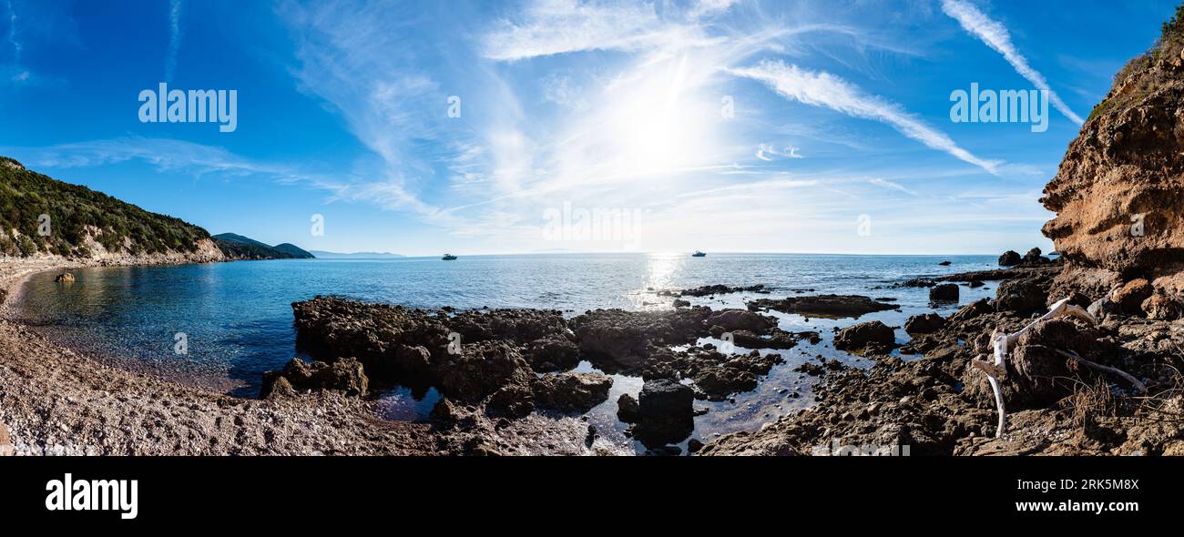 A scenic panoramic shot of the blue sea and rocky shoreline in Maremma ...