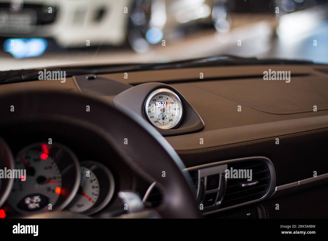 Brown leather dashboard in a porsche sports car with focus on analog ...