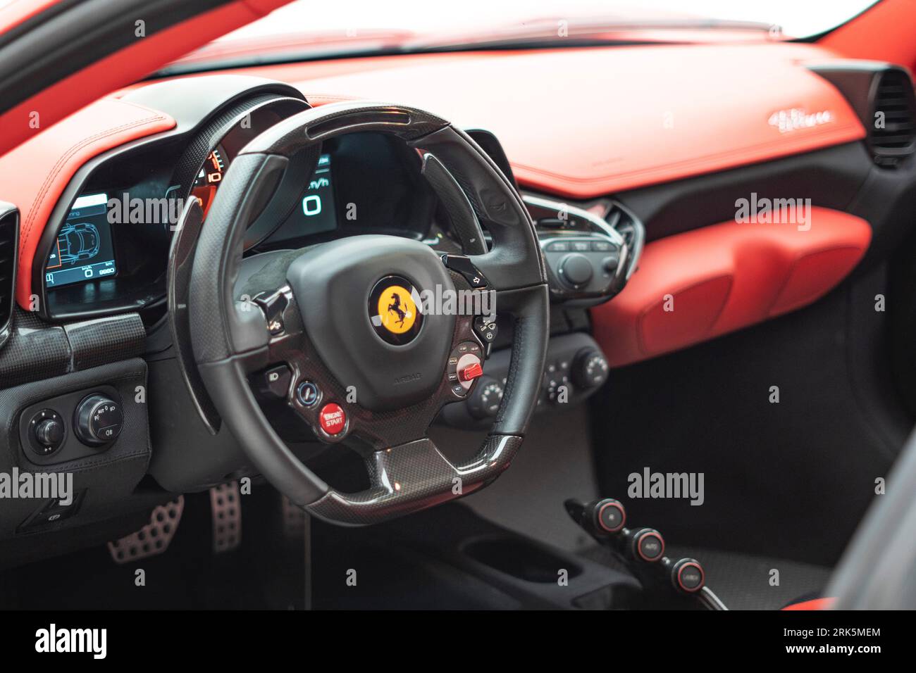 The interior of a red Ferrari 488 sports car with a digital display ...