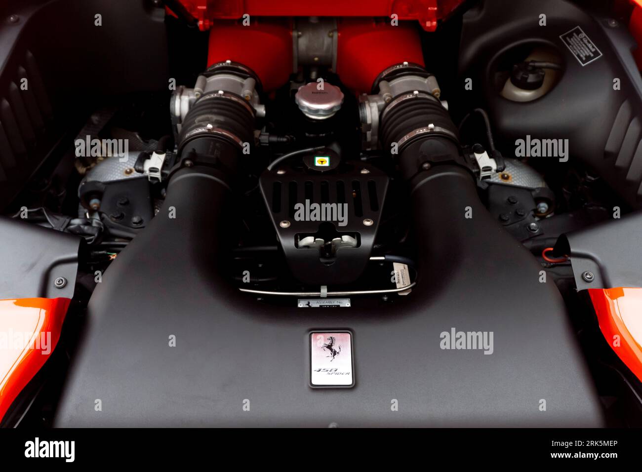 A closeup of the engine compartment of a Ferrari with the hood open ...