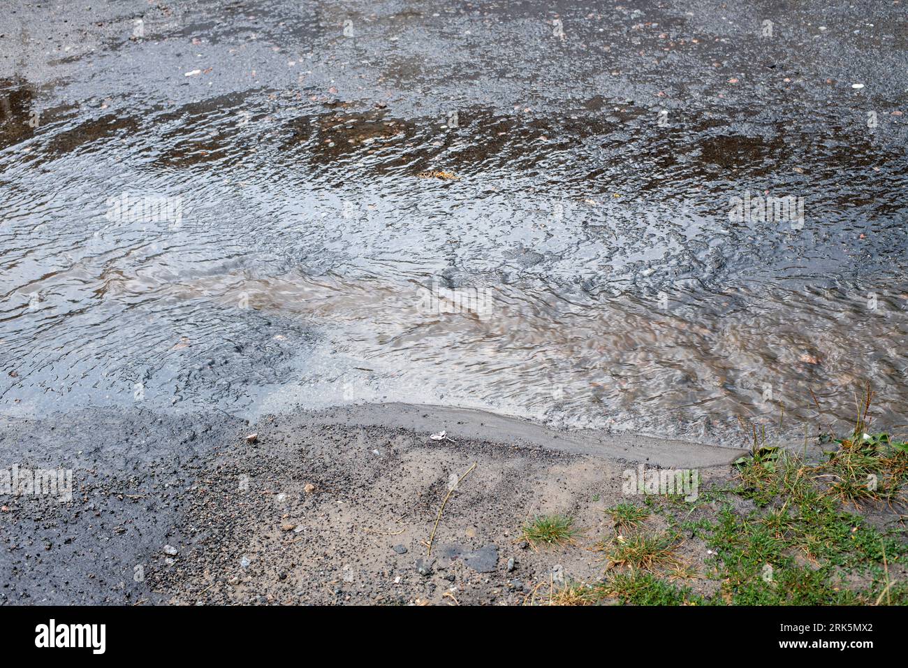 Water flow on the road .Road after winter Stock Photo - Alamy
