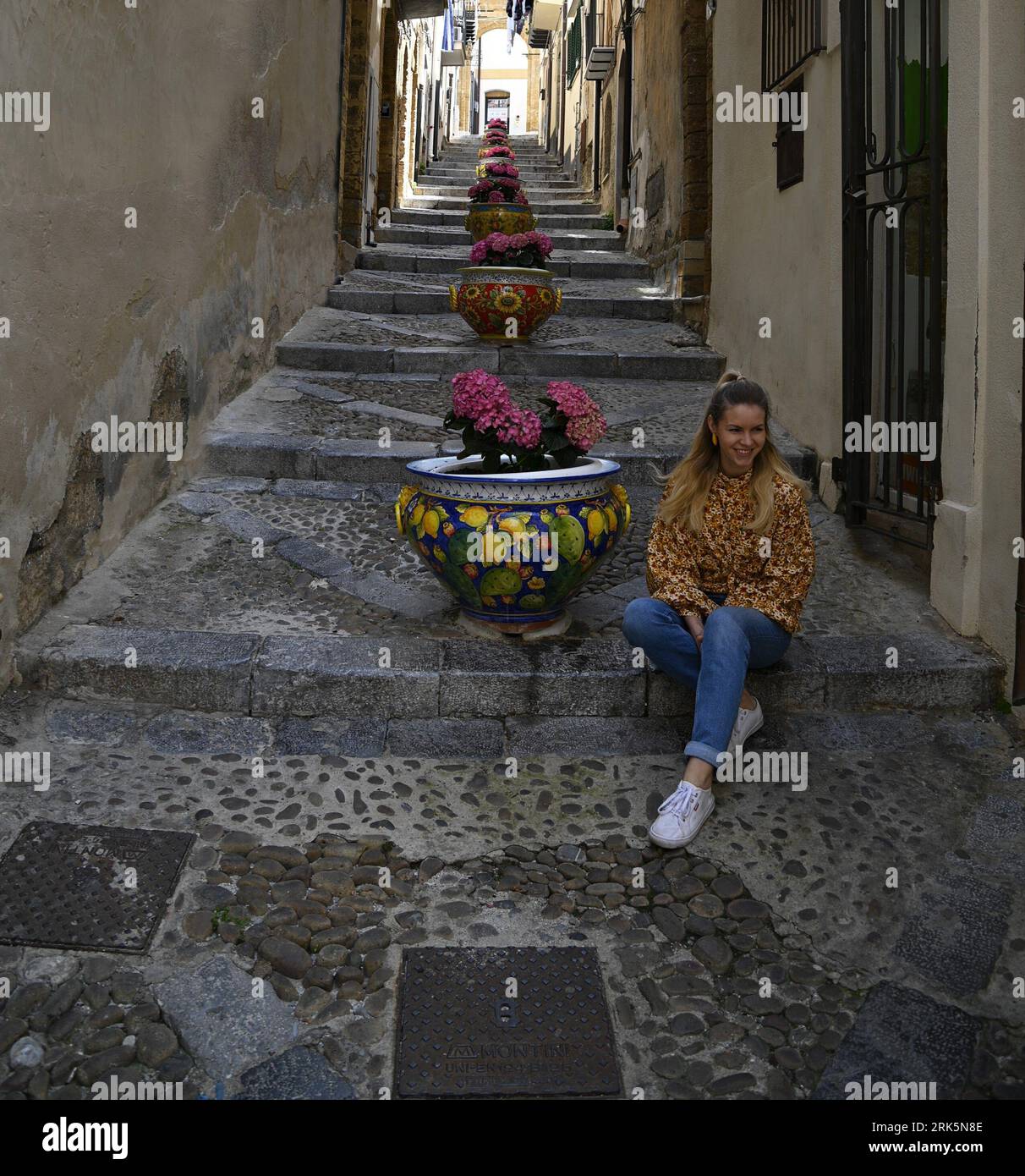 Young girl sitting next to colorful Sicilian Majolica planters on the ...