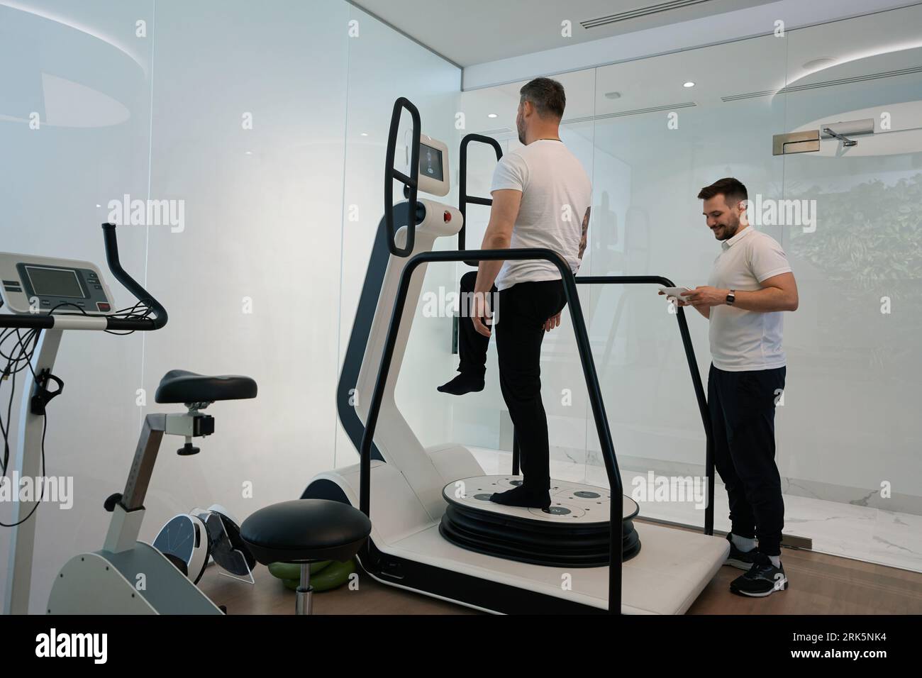 Patient performing one-leg balance exercise on equipment with ...
