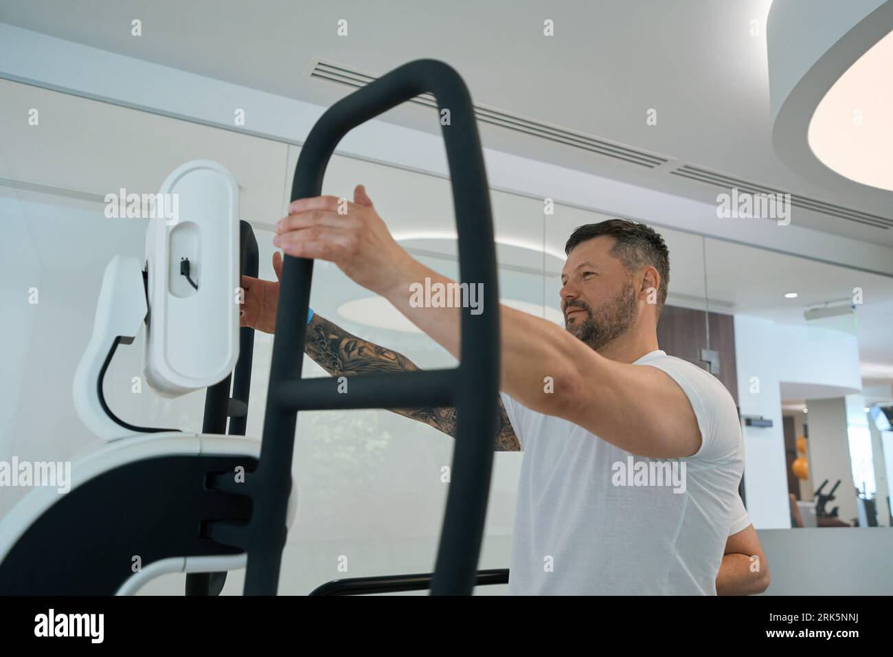Patient undergoing physical rehabilitation on modern fitness equipment ...