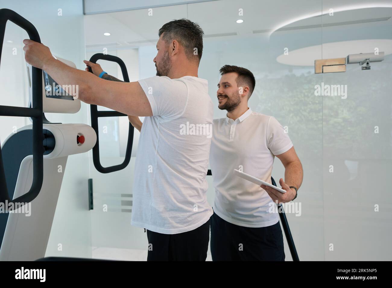 Patient exercising on modern rehabilitation equipment Stock Photo - Alamy