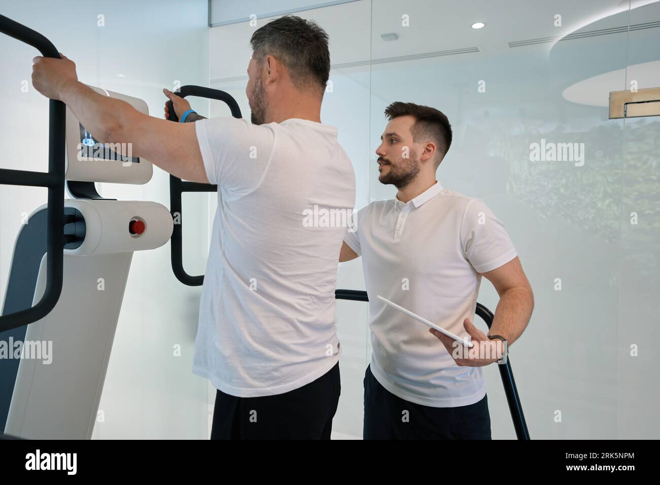 Man training on multi-axis motorized platform supervised by physical ...