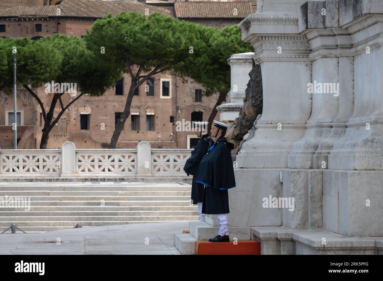 Two men wearing military uniforms are standing side by side in front of ...