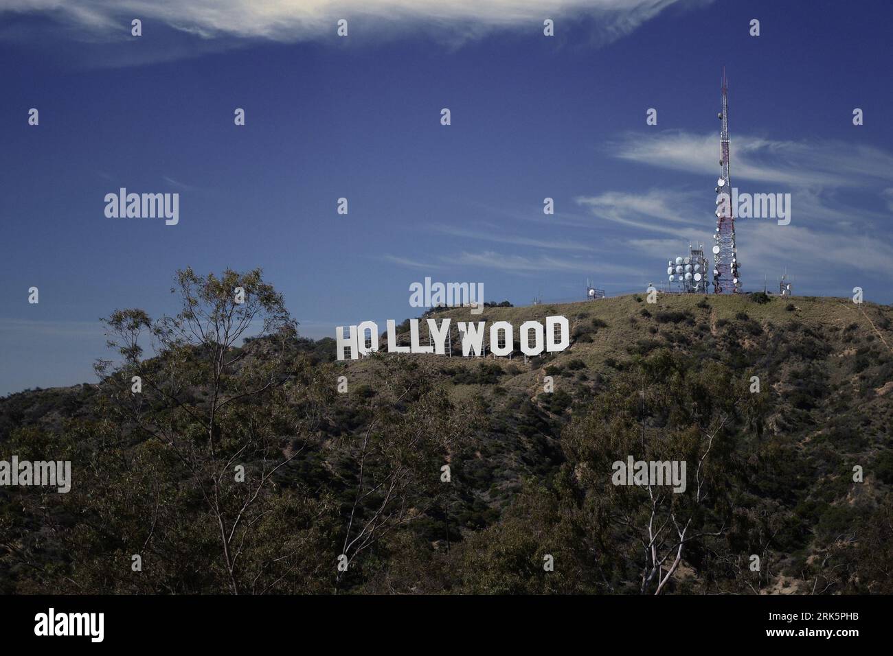 The iconic Hollywood Sign is perched atop an elevated hill, surrounded ...