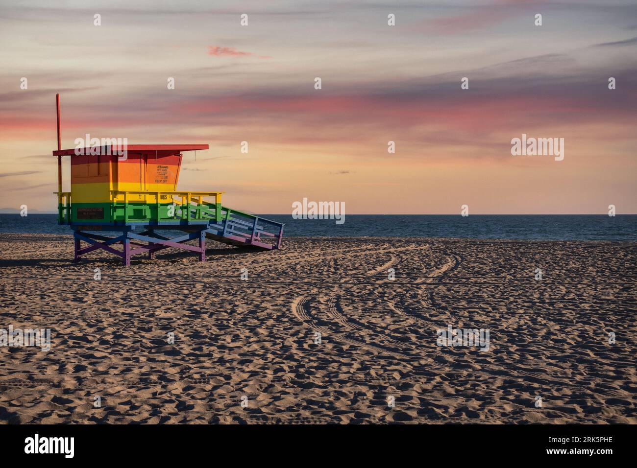 An empty life guard stand silhouetted against a stunning backdrop of a ...