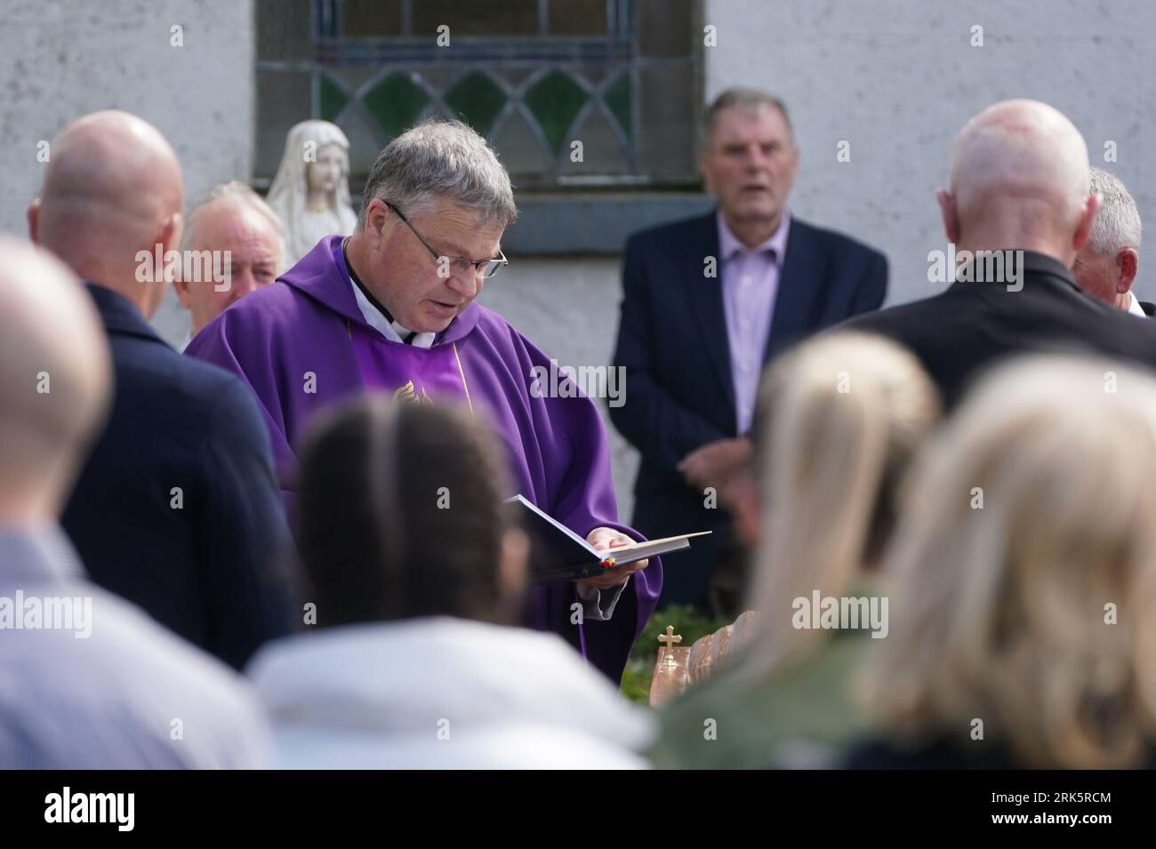 Father Gerry Boyle blesses the coffin of Brendan Wall as it arrives at ...