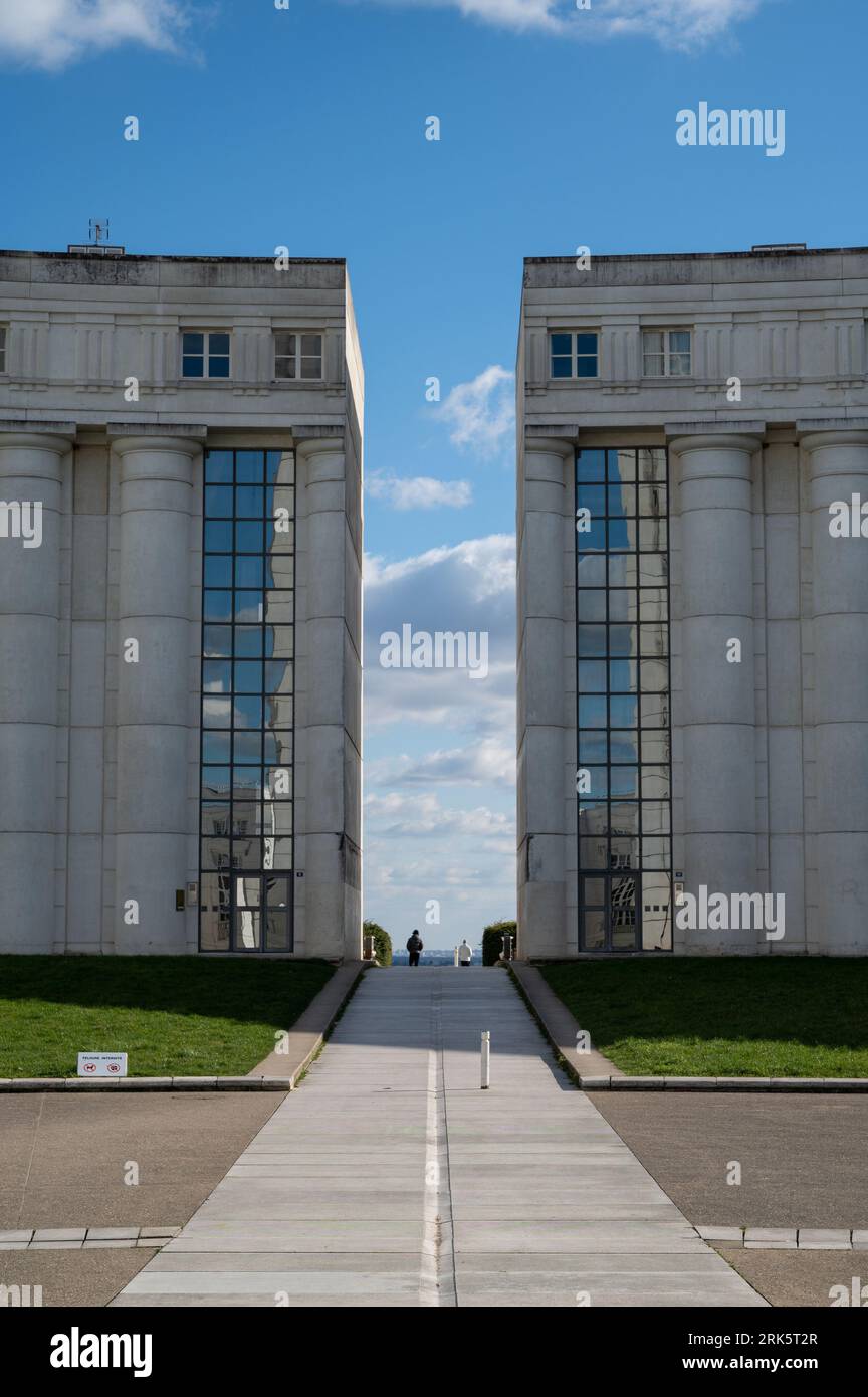 A symmetrical walkway between two modern office buildings, surrounded ...