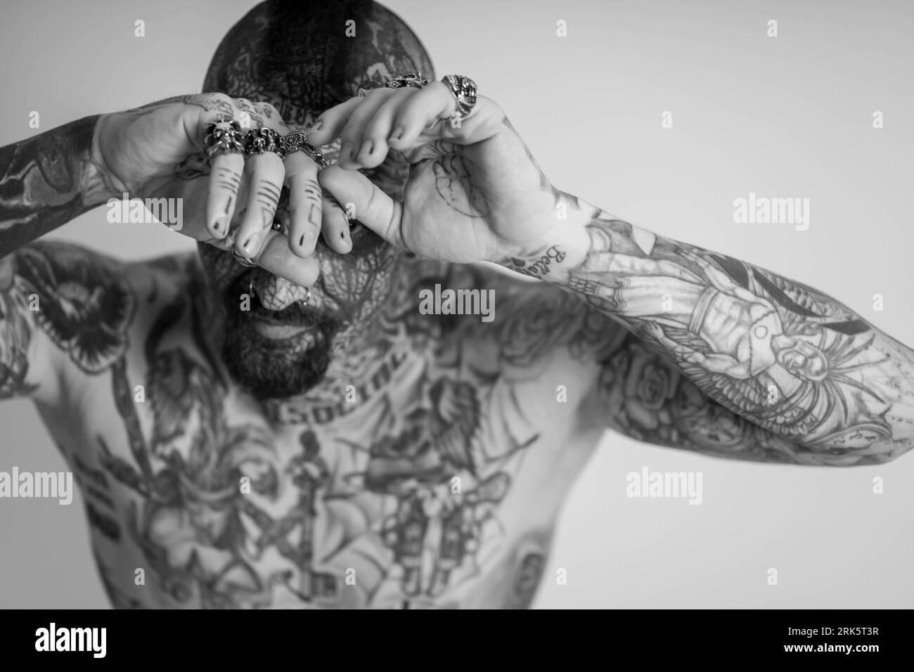 A grayscale of a Caucasian man with whole body covered in traditional ...