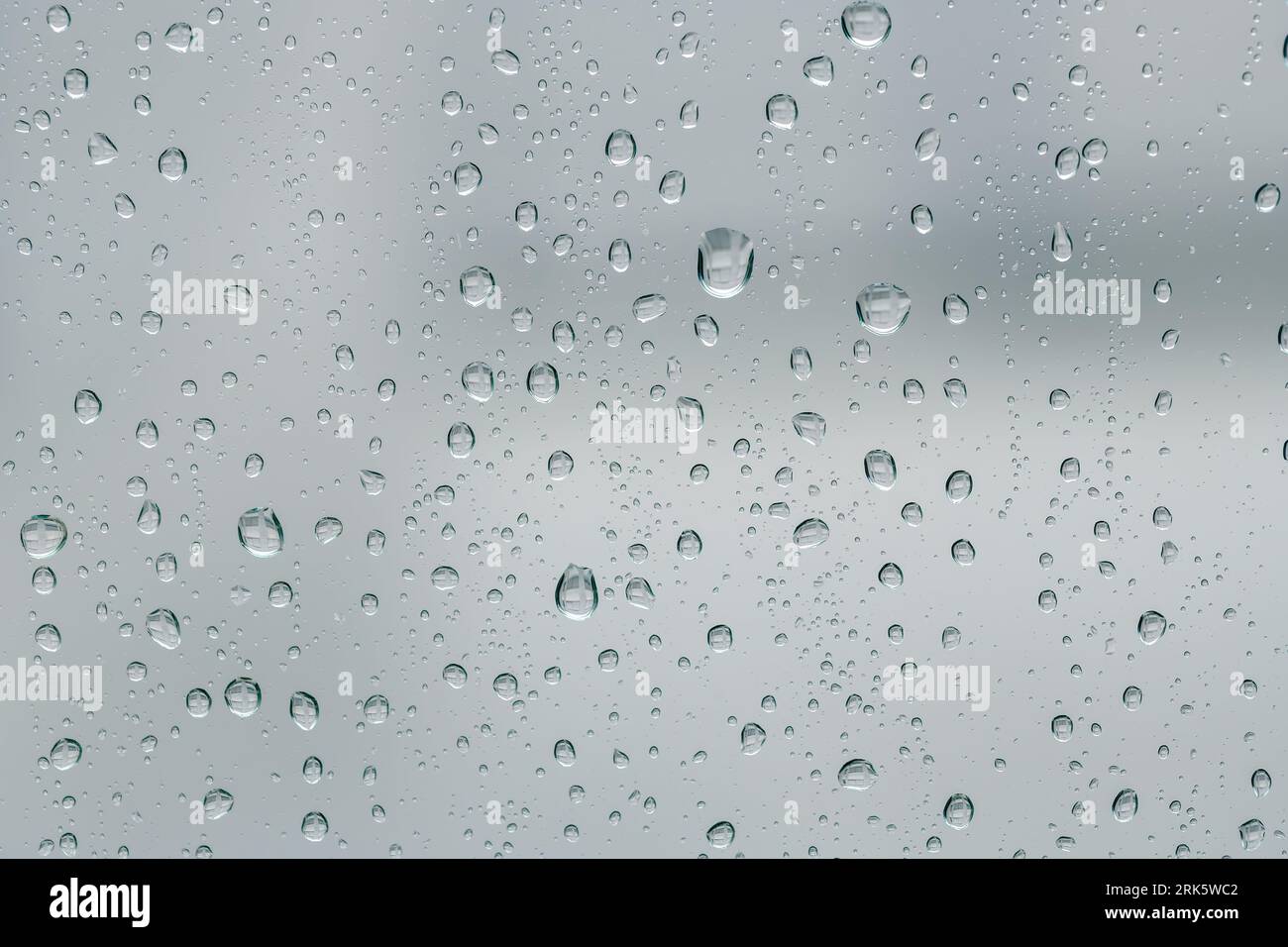 A close-up view of a glass windowpane covered in rainwater droplets Stock Photo - Alamy