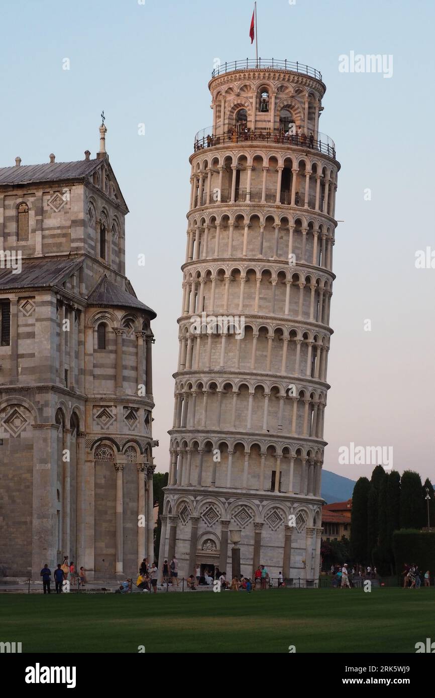 A group of people stands together in front of the iconic Leaning Tower ...