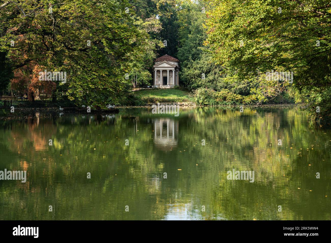 A beautiful classic structure on the lakeside surrounded by lush greenery in the park of Monza ...