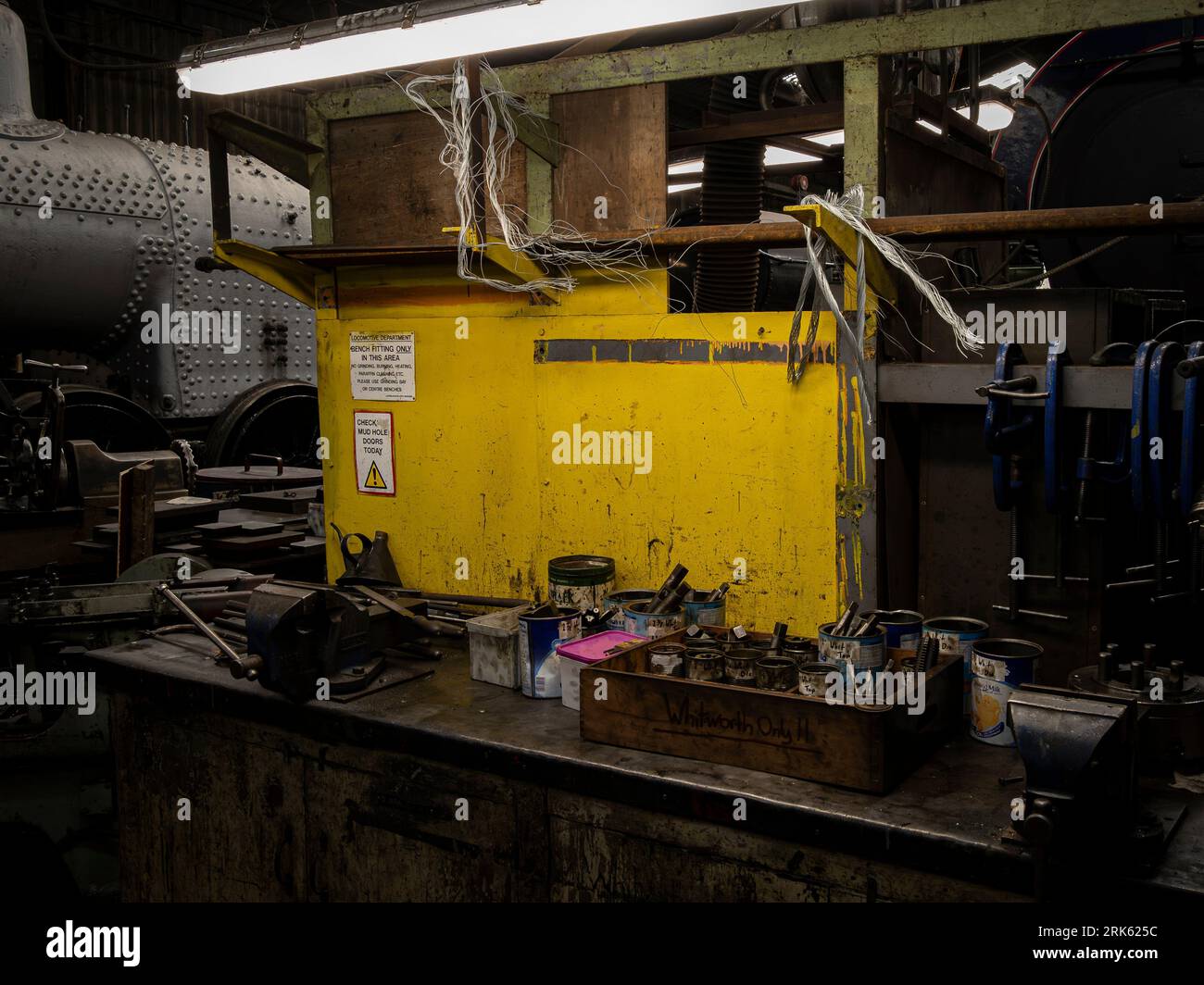 A close-up view of a workbench, featuring a variety of mechanical tools ...