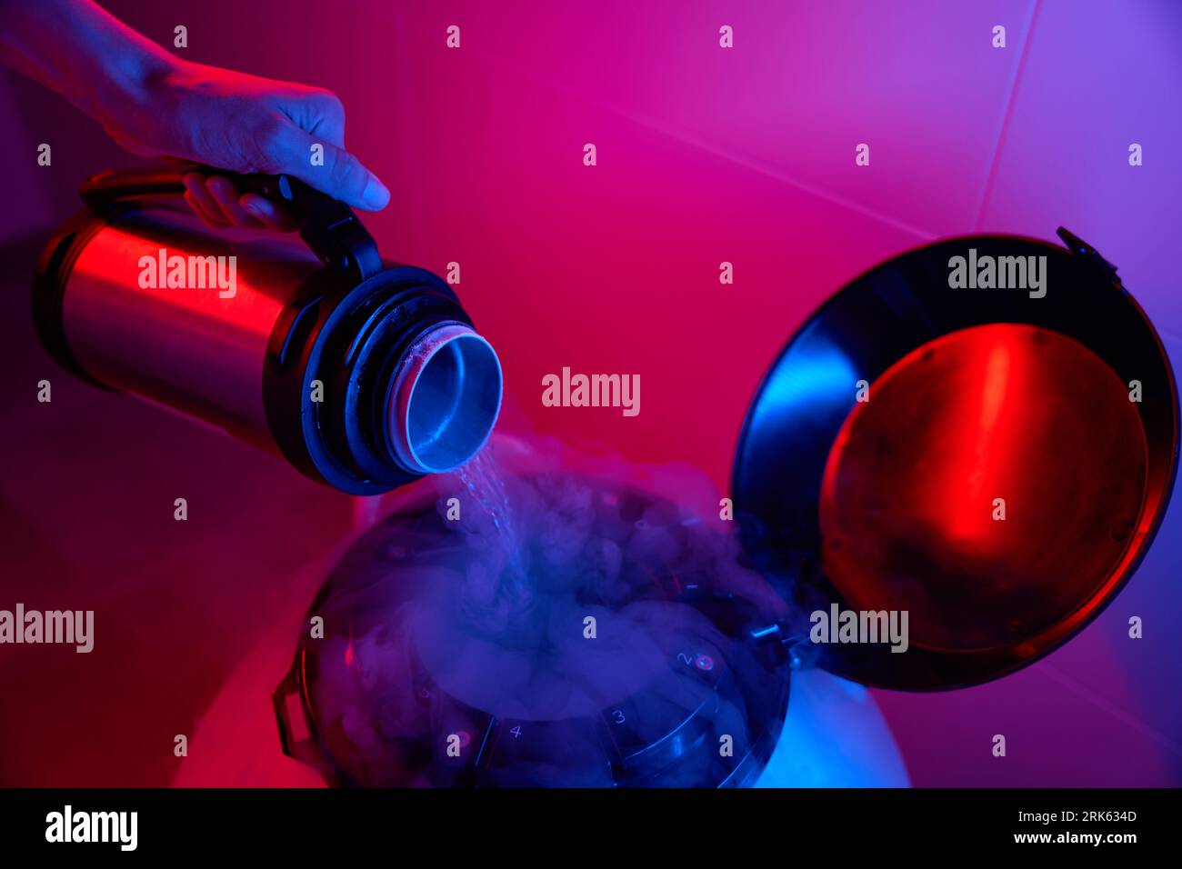 Laboratory assistant pours liquid nitrogen into the cryocapsule Stock ...