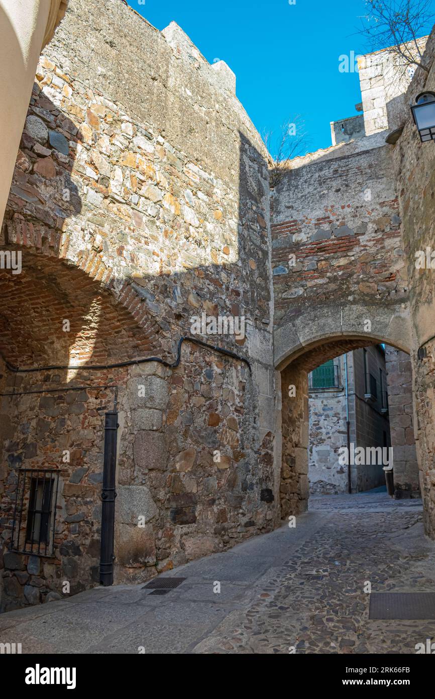 A cobblestone street lined with traditional stone buildings leads to a ...