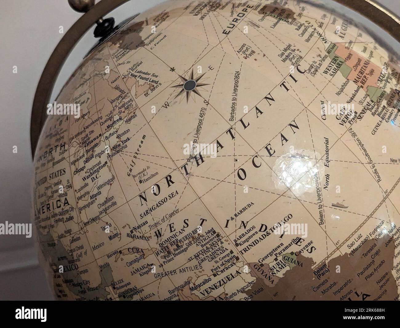 This antique globe features a detailed metal frame and a vintage map ...