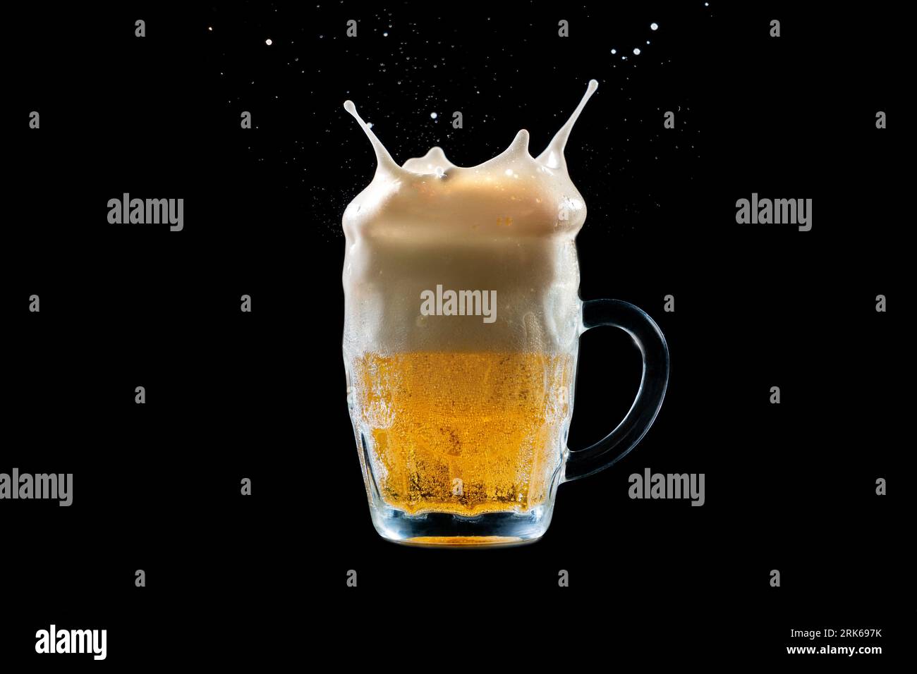 A close-up shot of a glass of beer with liquid being poured around the ...