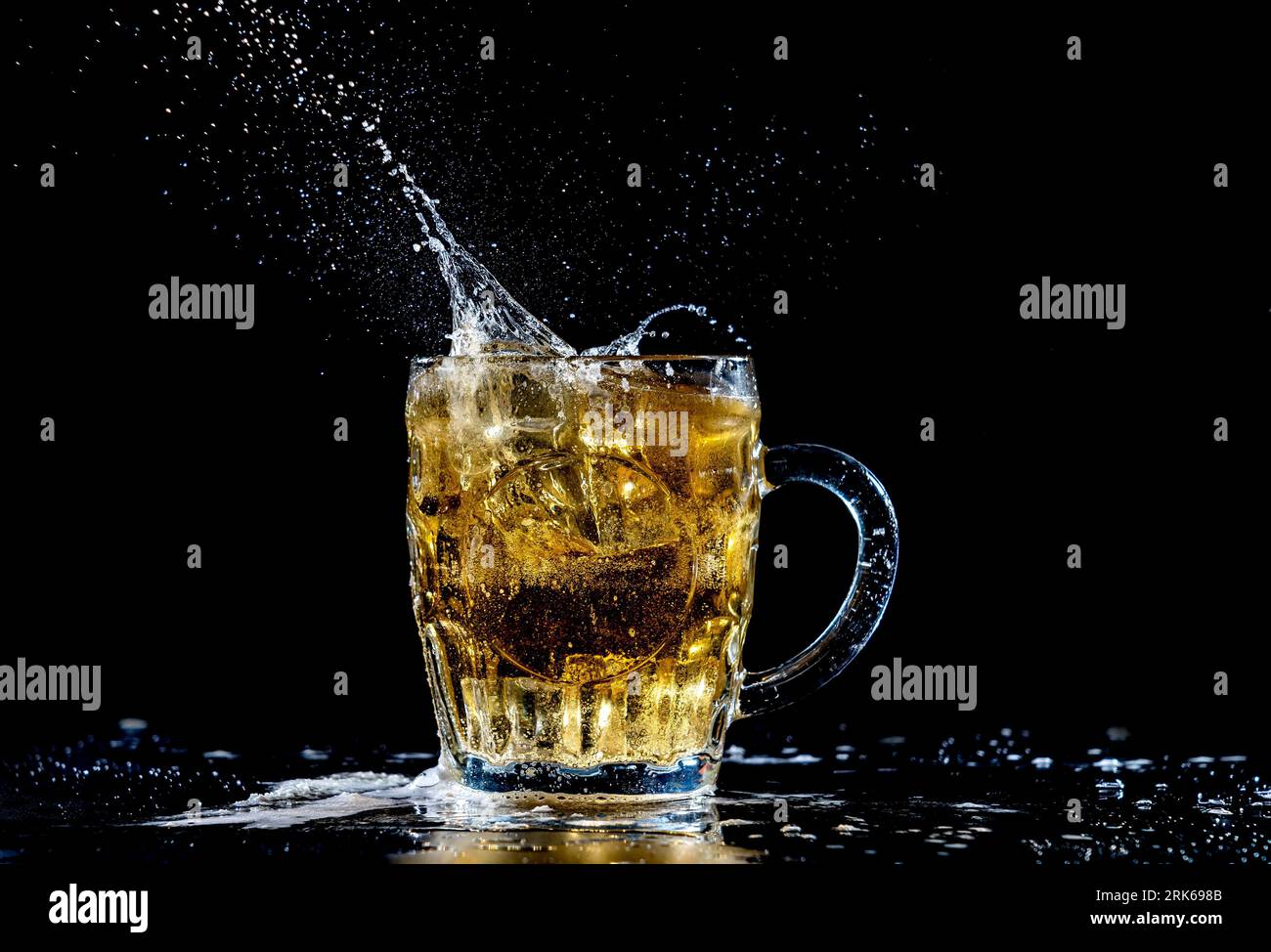 Close-up shot of a beer glass overflowing with golden lager beer ...