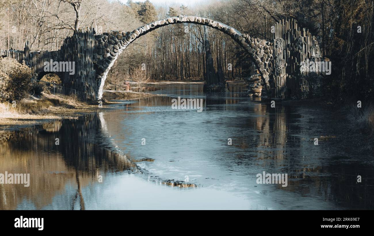 A picturesque landscape featuring a majestic stone arch bridge crossing ...