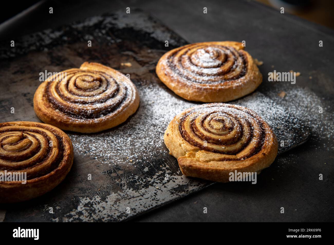 A freshly-baked batch of delicious cinnamon rolls sits on a baking ...