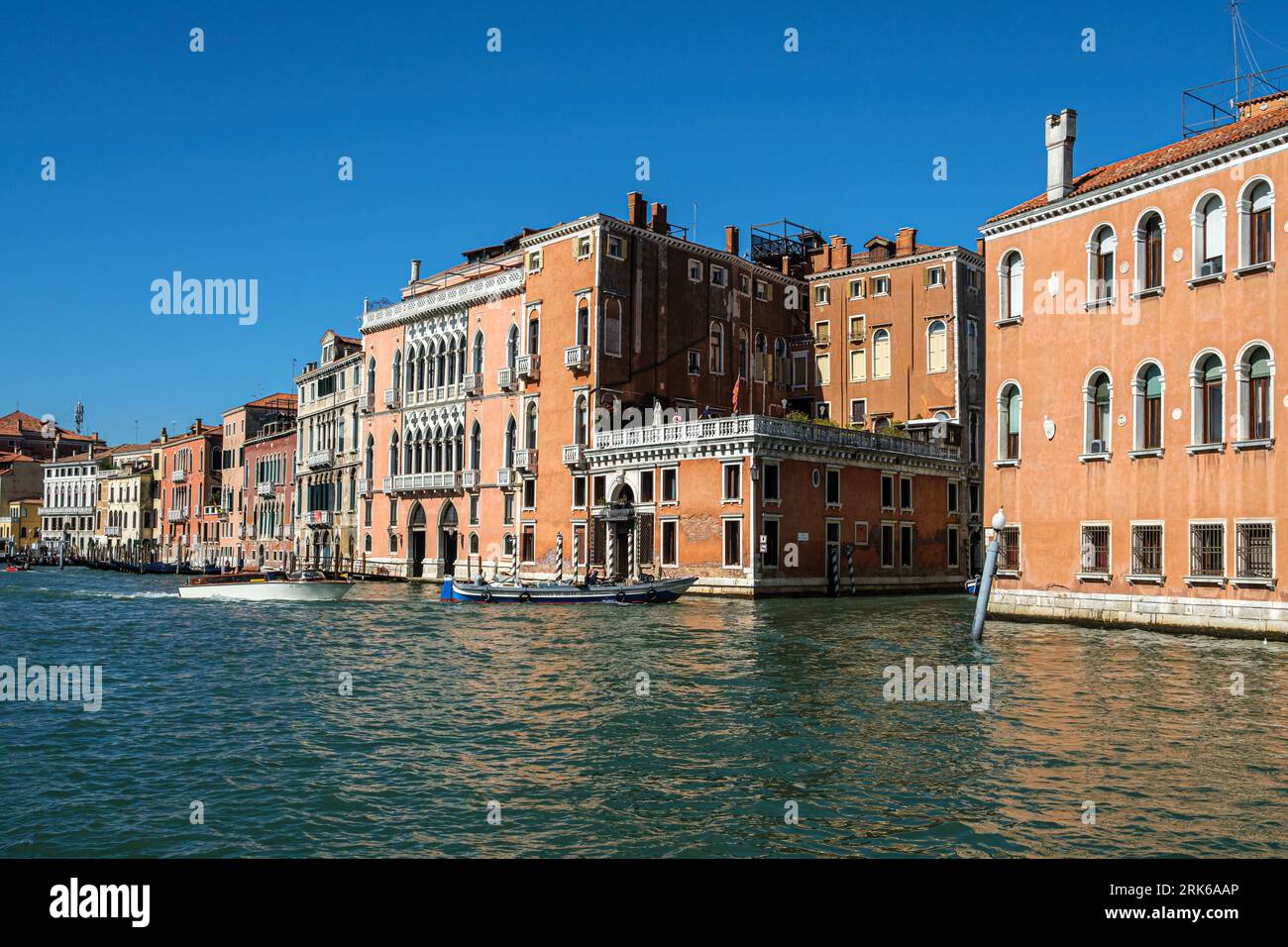 Multiple boats are docked in front of an urban waterfront, with a line ...