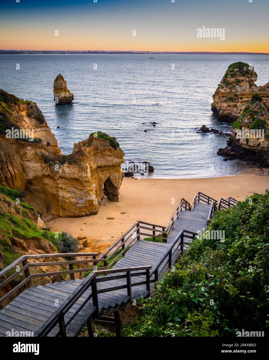 An idyllic scene in Lagos, Portugal of a set of wooden steps leading ...