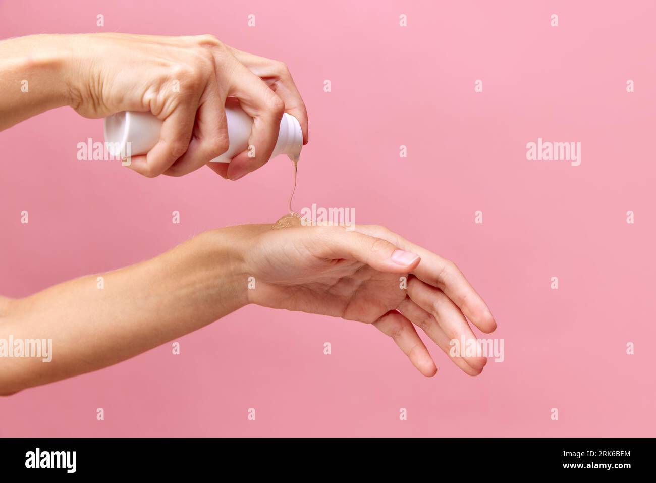 Woman's hand squeezing cream, gel for hands from unmarked bottle with ...