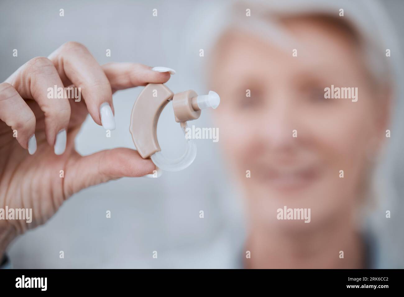 Hand, closeup and hearing aid with senior woman for audio, sound or ...