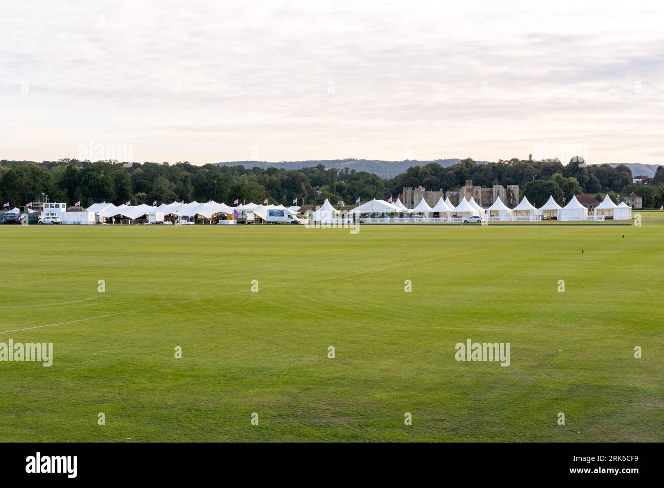 A group of tents and camping equipment set up on the grassy field in ...