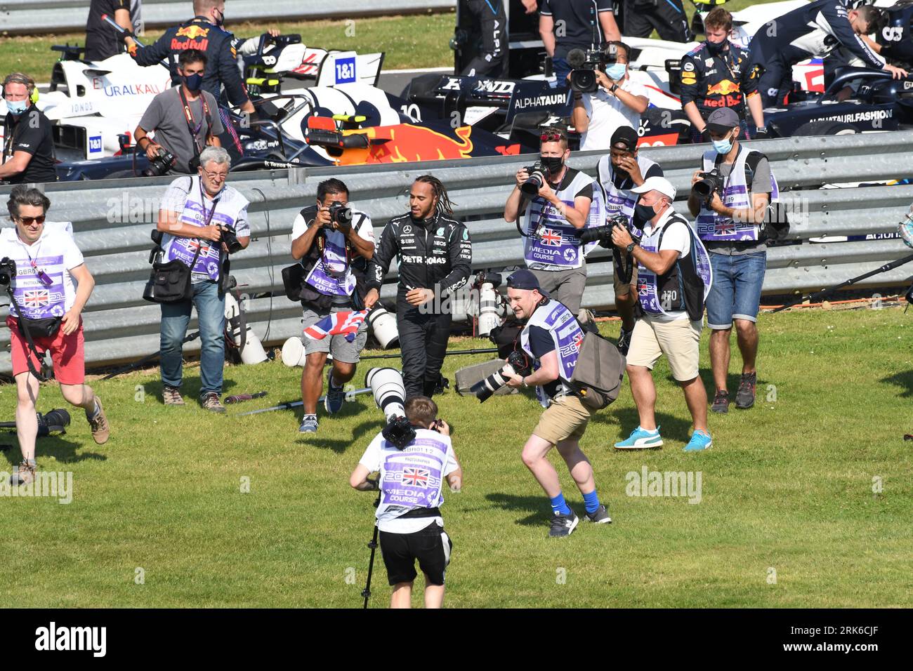 A diverse group of photographers are gathered together in a lush green ...