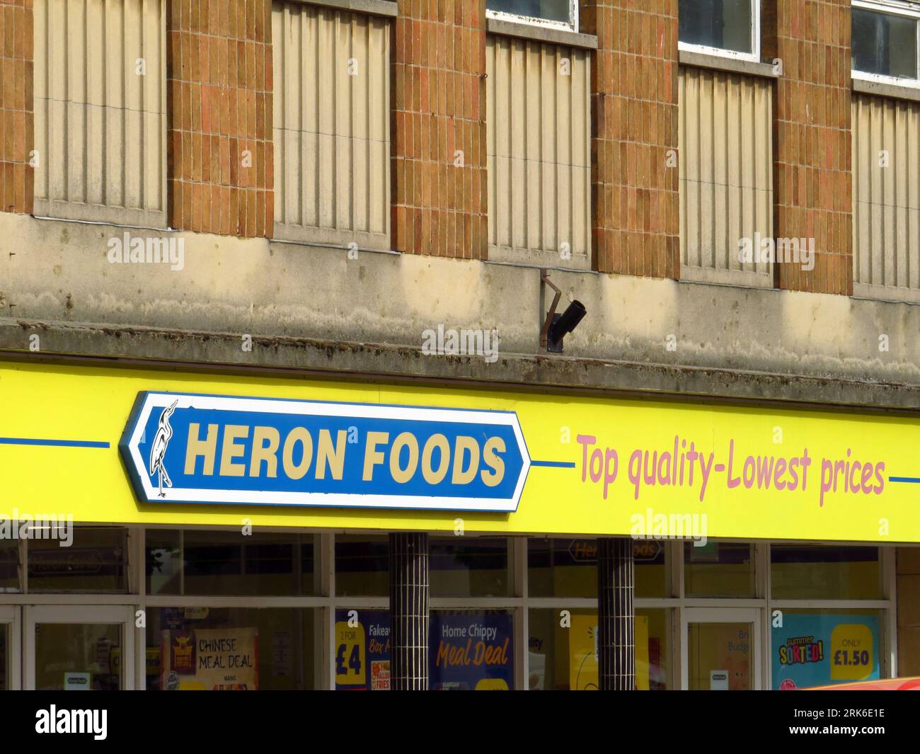 Close-up of Heron Foods supermarket sign with 'Top quality - Lowest ...