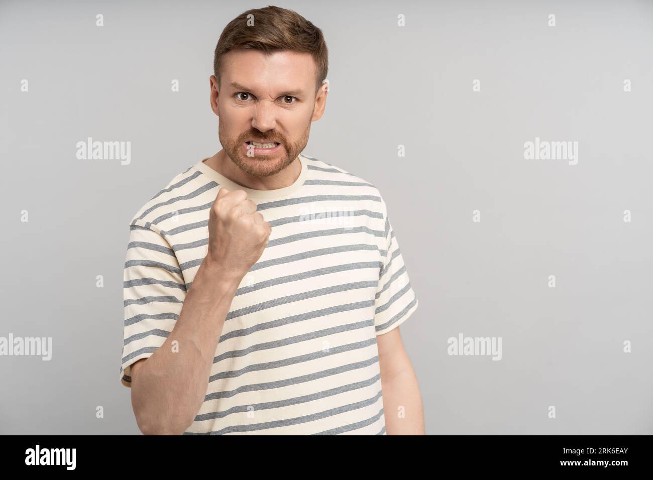 Angry aggressive man shows fist. Man in rage threatens with physical ...