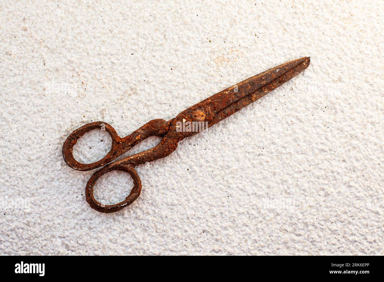 Old vintage scissors covered in rust on white stone background ...