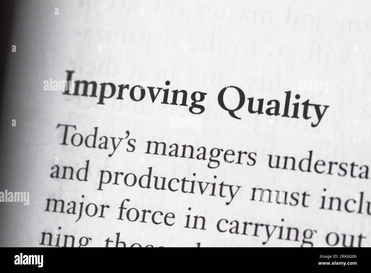 A close-up of a business textbook with the term 'improving quality ...