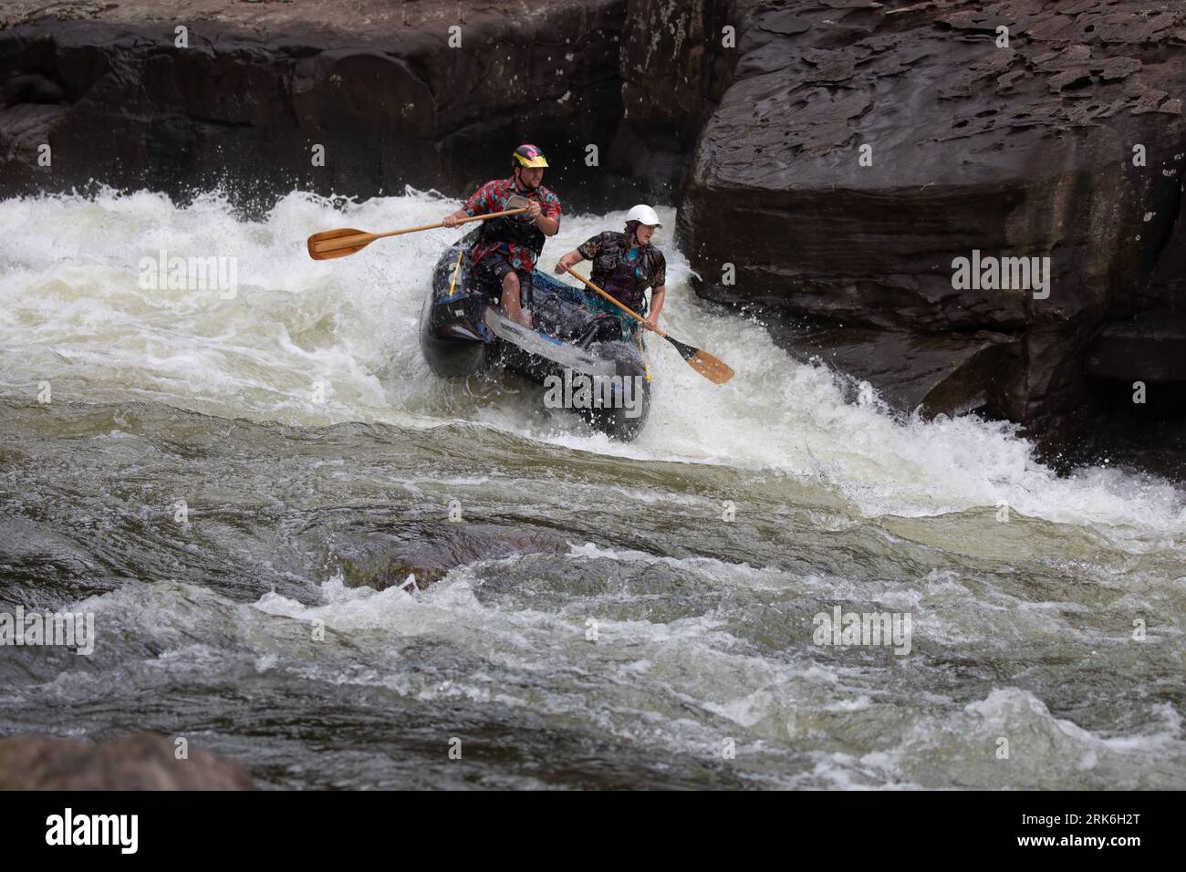 A group of people in a kayak navigating through the choppy waters of a ...
