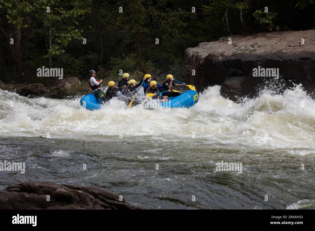 A group of people in a kayak navigating through the choppy waters of a ...