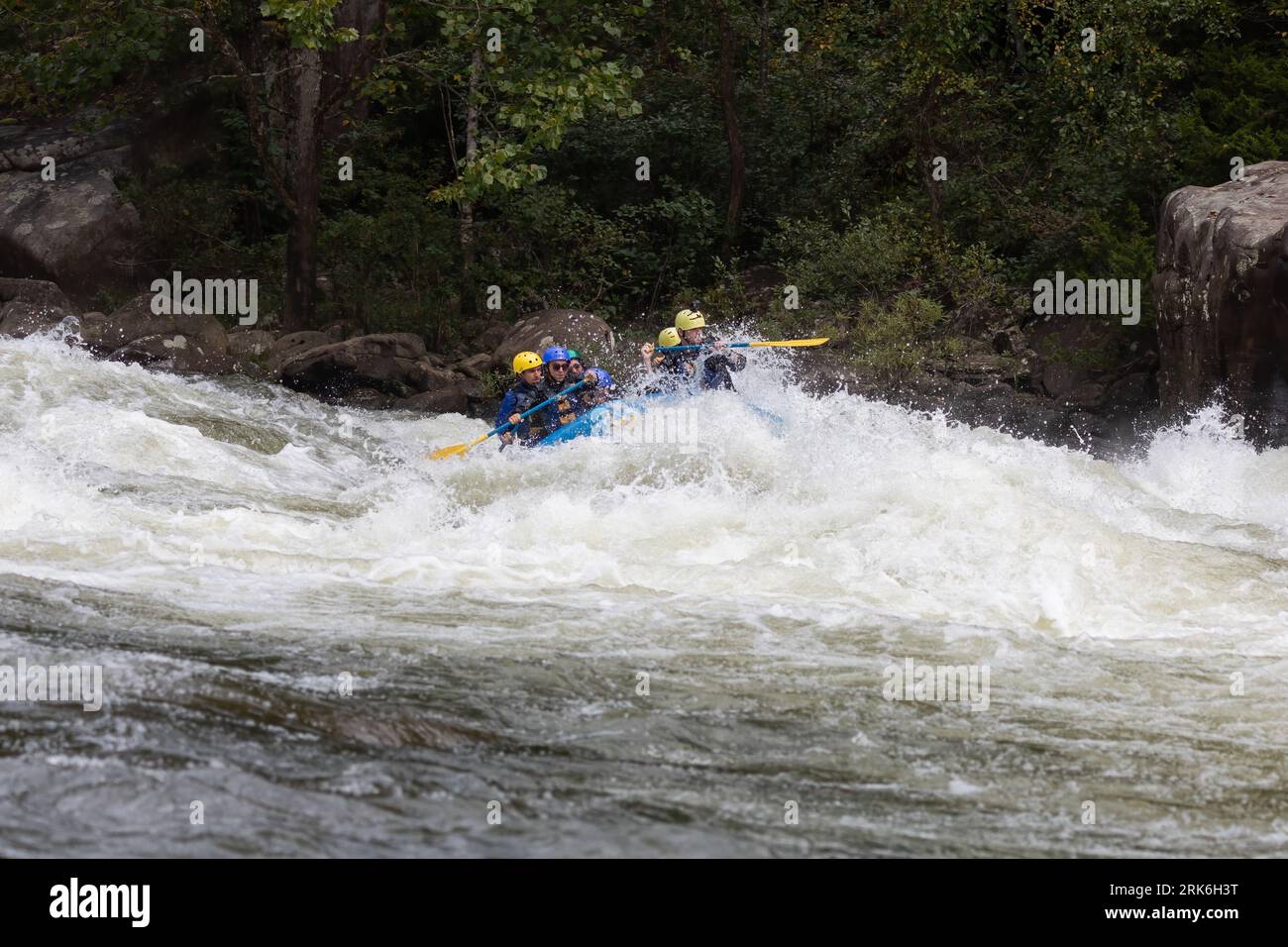 A group of people in a kayak navigating through the choppy waters of a ...